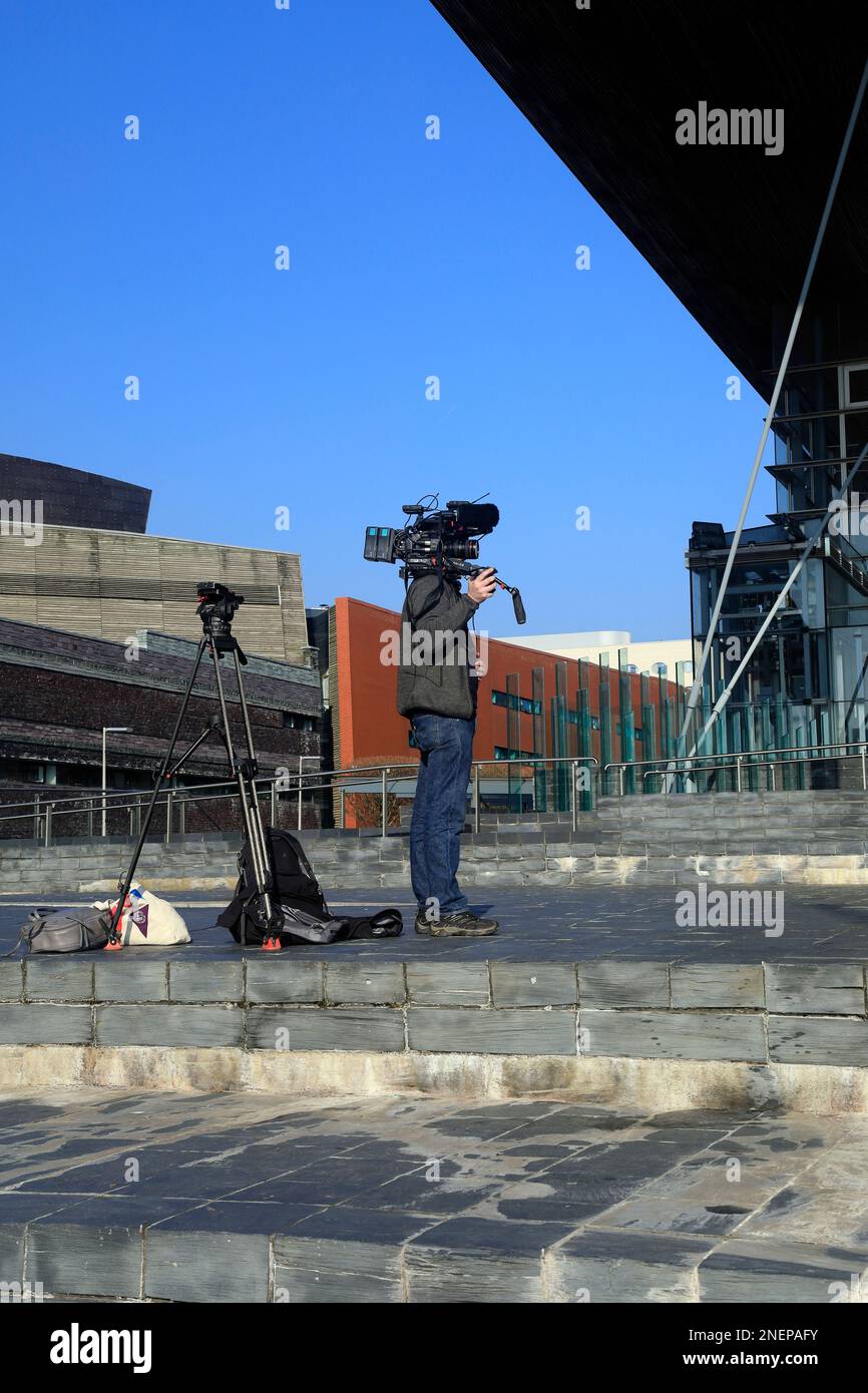 Filming a piece-to-camera outside the Senedd building, Cardiff Bay ...