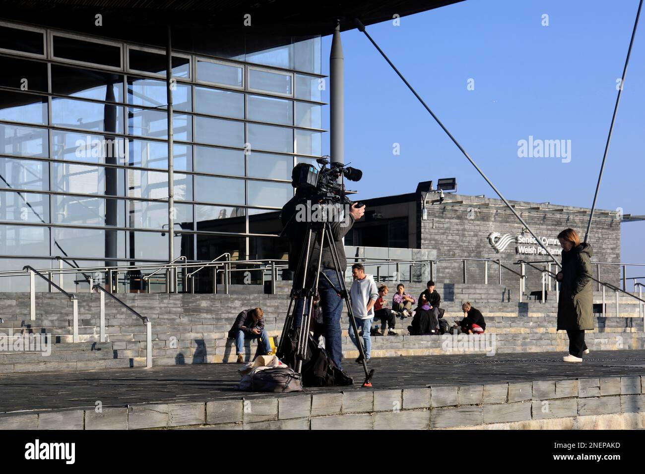 Filming a piece-to-camera outside the Senedd building, Cardiff Bay ...