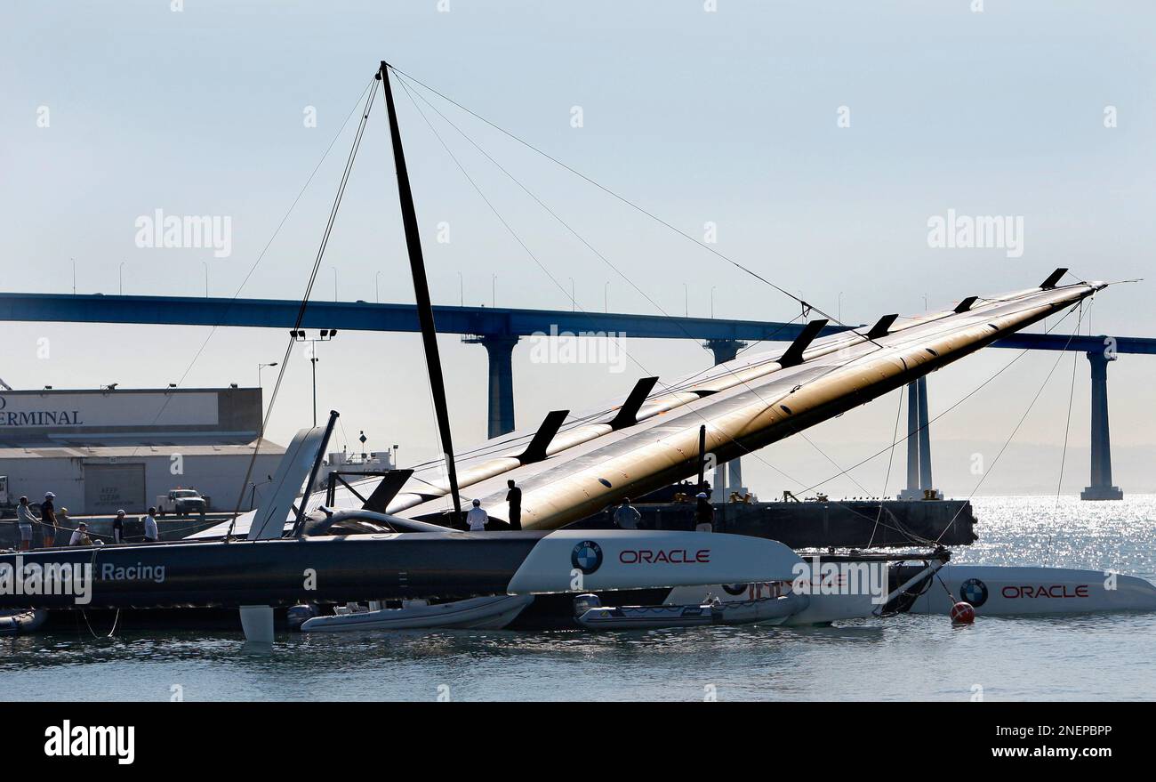 Crew members of the BMW Oracle America's Cup Racing team raise a giant ...