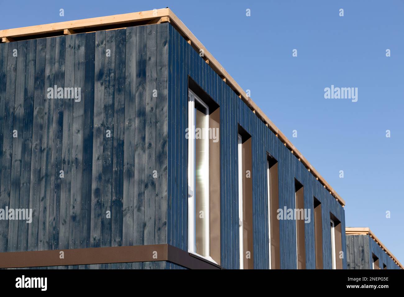 Wooden facade of a separate modular house with windows. Close-up Stock ...