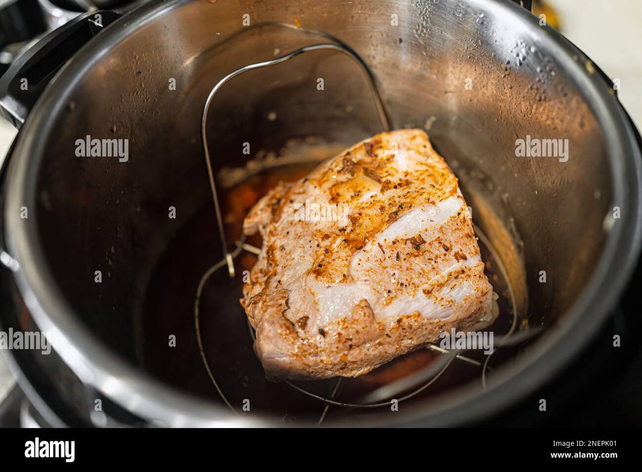 Closeup of cooked boneless pork loin meat on rack in pressure cooker ...