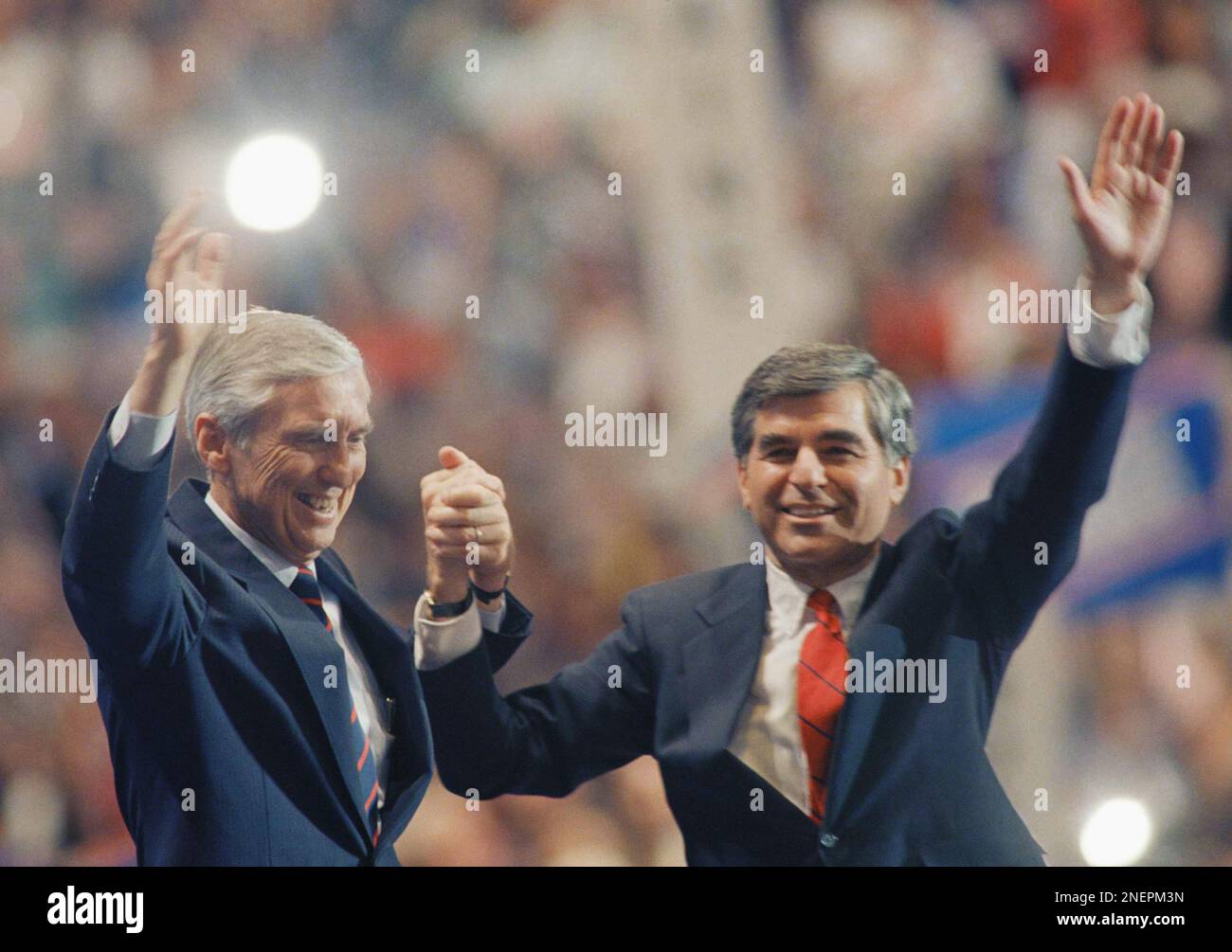 Michael Dukakis , right, raises hand of running mate Sen. Lloyd Bentsen ...