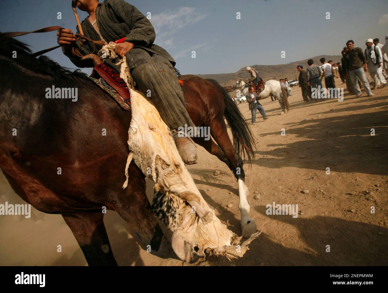An Afghan buzhkashi player drags a beheaded goat during a game in Kabul ...
