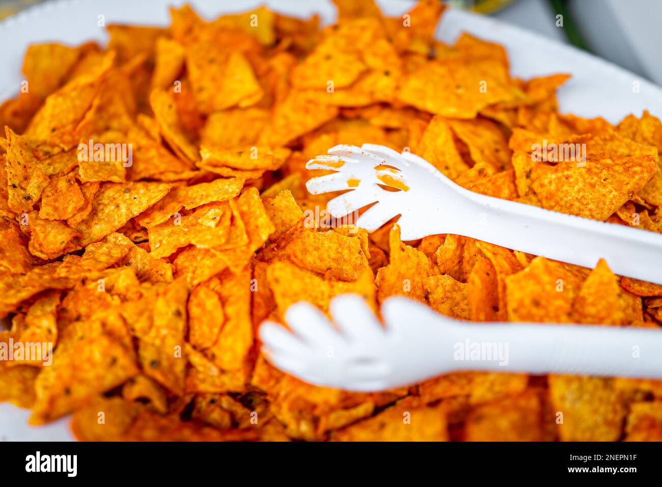 Macro closeup of corn spicy cheesy orange tortilla chips in bowl plate ...