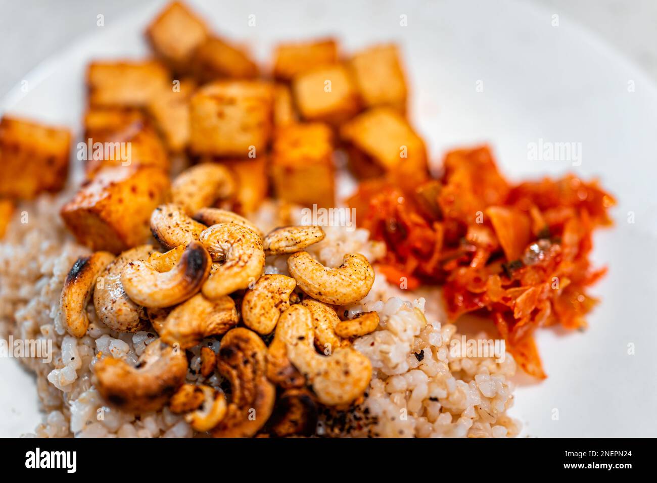 Baked tofu cubes, spiced cashews on brown rice and pickled kimchi ...