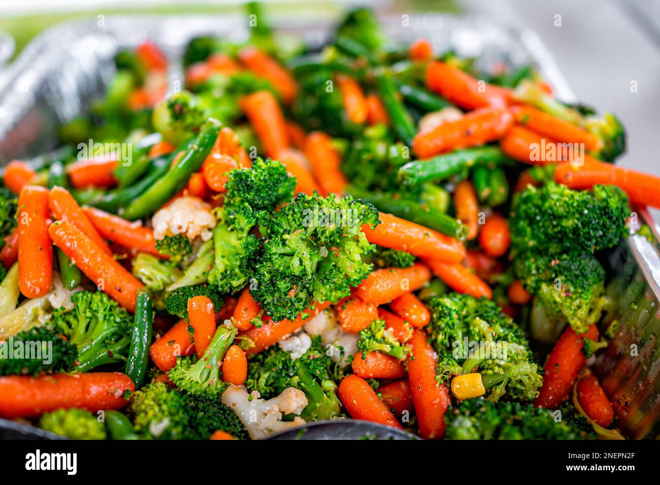 Steamed broccoli with baby carrots and green beans in buffet tray at ...