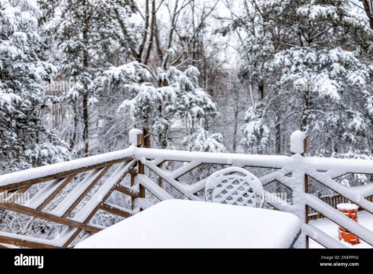 White snow covered metal outdoor table chair closeup on home house ...