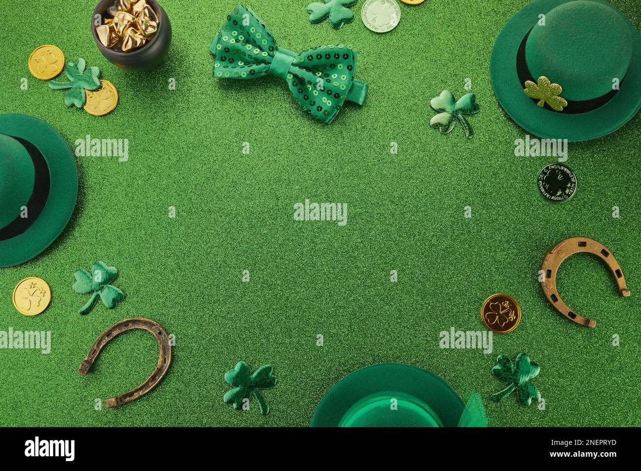 St Patricks Day frame of shamrocks, gold coins and leprechaun hat over ...