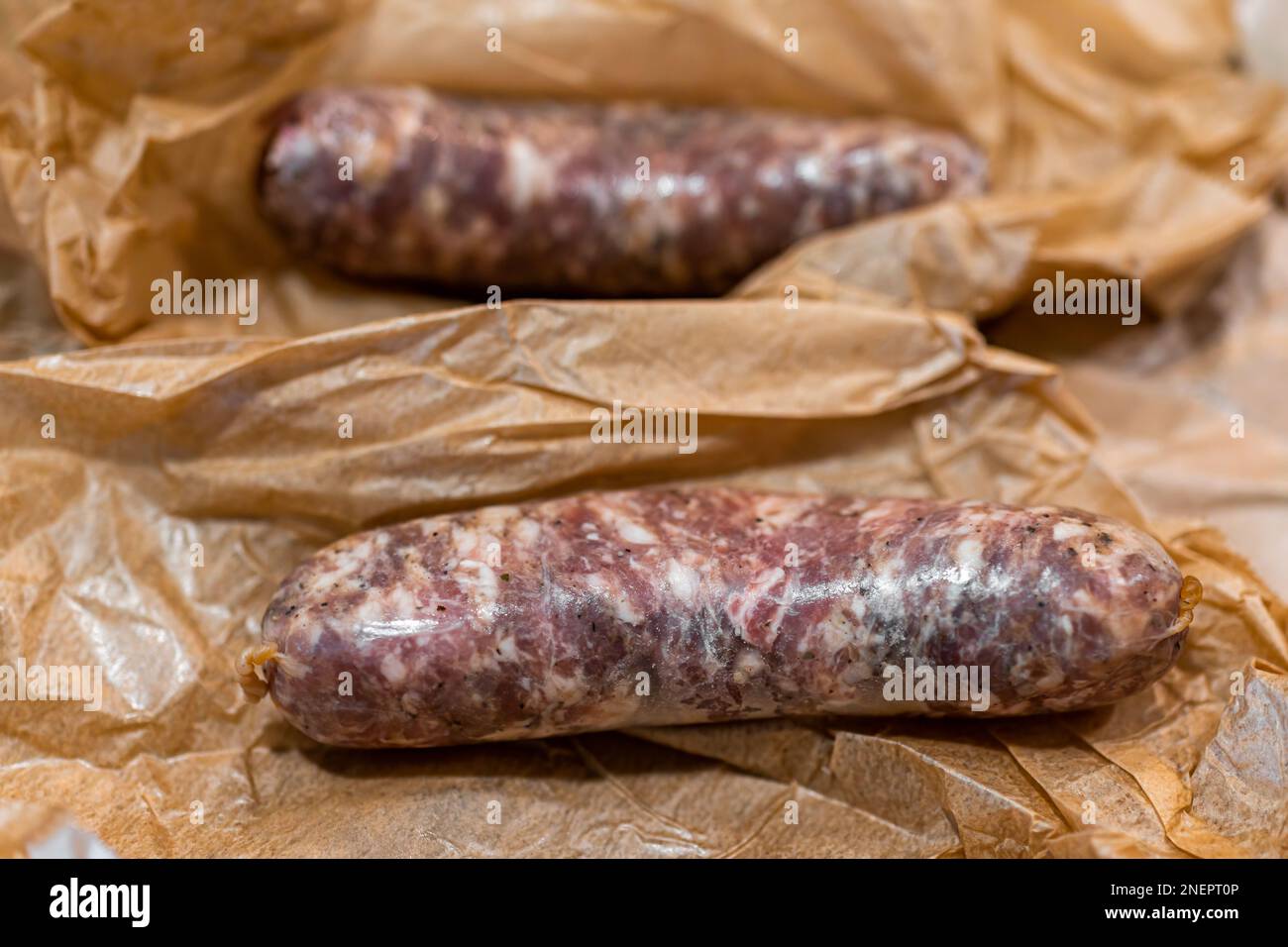 Two Italian pork sausages with plastic paper butcher packaging closeup ...