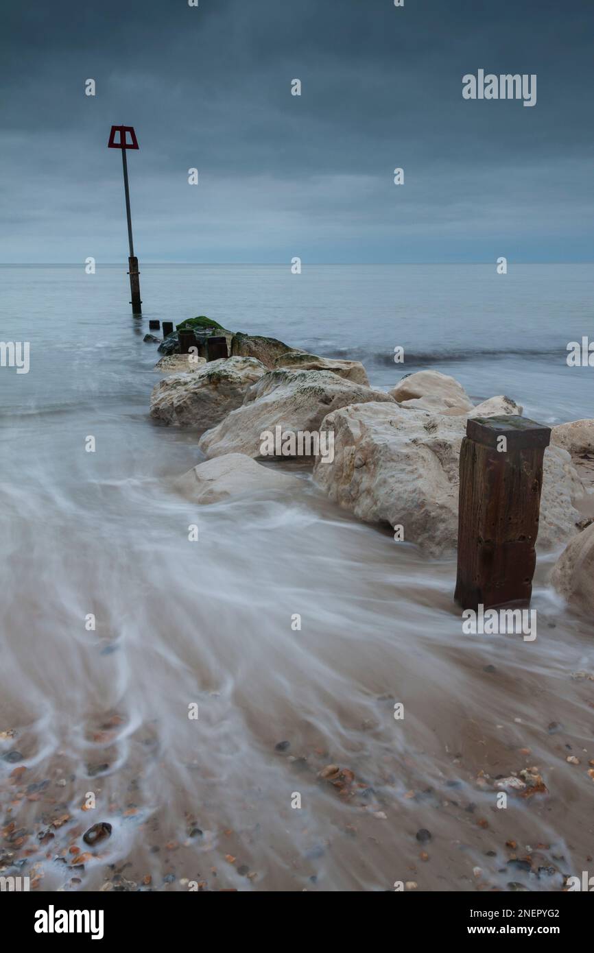 Rock and timber sea defence with tide pullback and moody sky, Avon ...