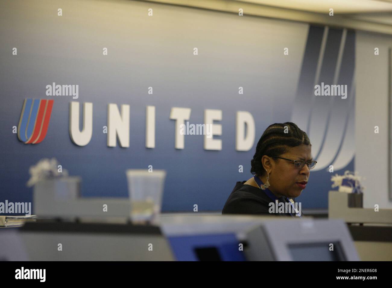 A ticket agent work behind the United Airlines ticket counter at ...