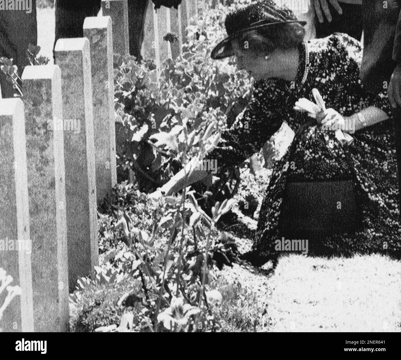 British Prime Minister Margaret Thatcher straightens out the flowers at ...