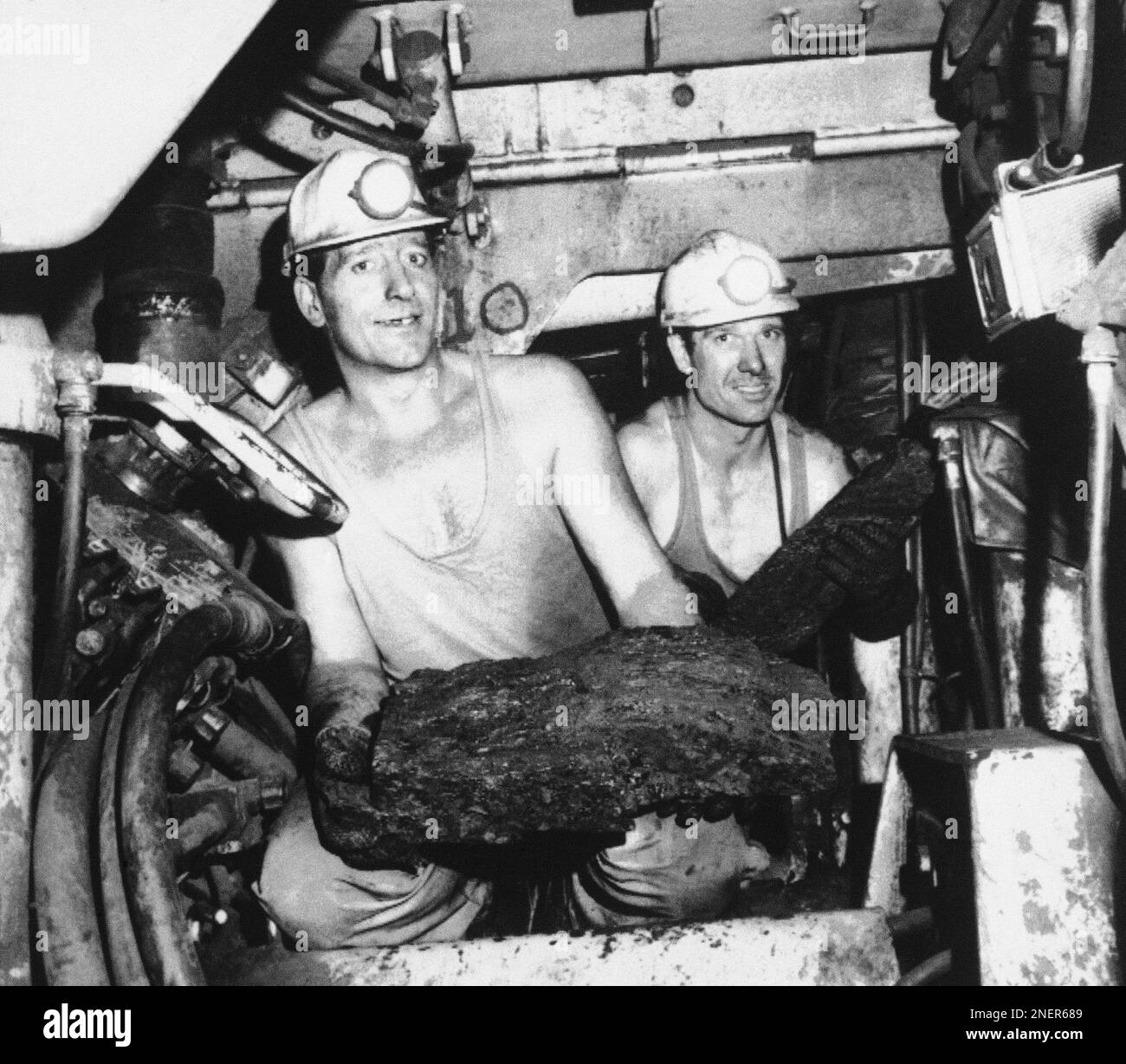Unidentified miners are shown with the first coal cut after a year-long ...