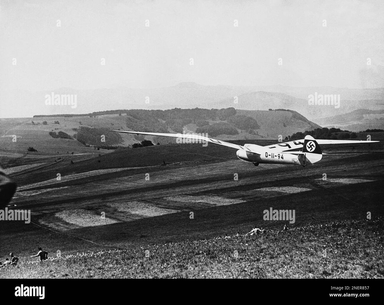 Bearing the Nazi Swastika, a German glider, soars over the Rhoen Hills ...