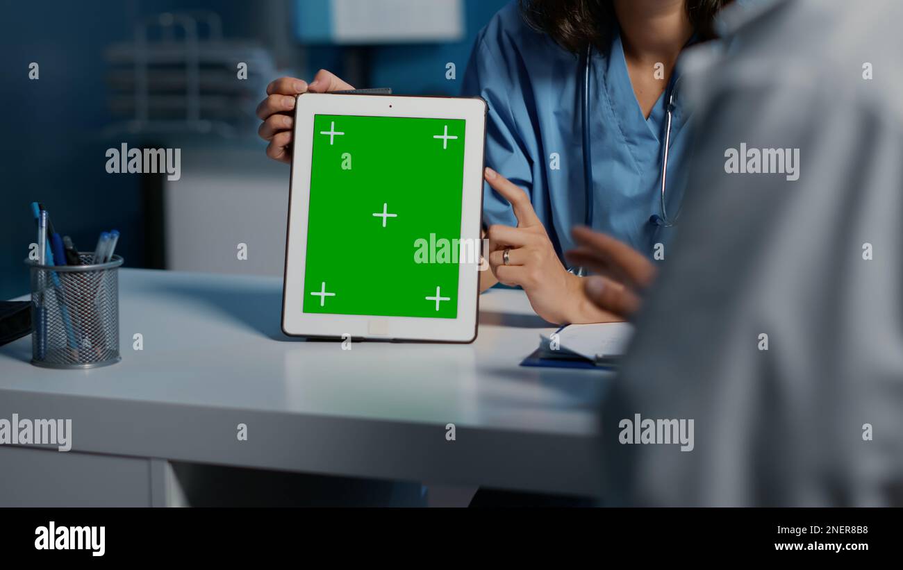 Assistant showing tablet computer with green screen template to ...