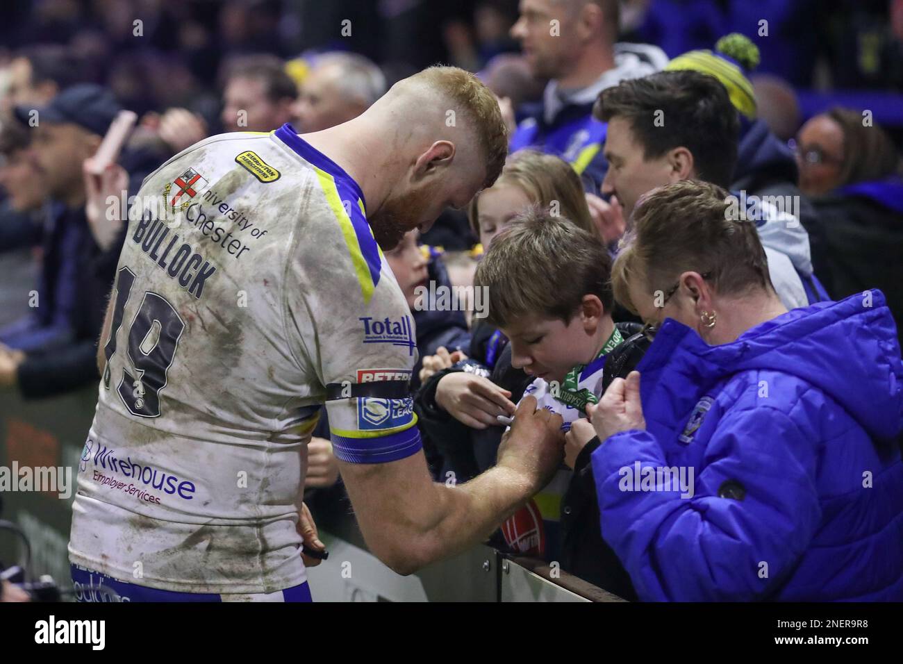 Joe Bullock #19 of Warrington Wolves signs a fans shirt after the ...