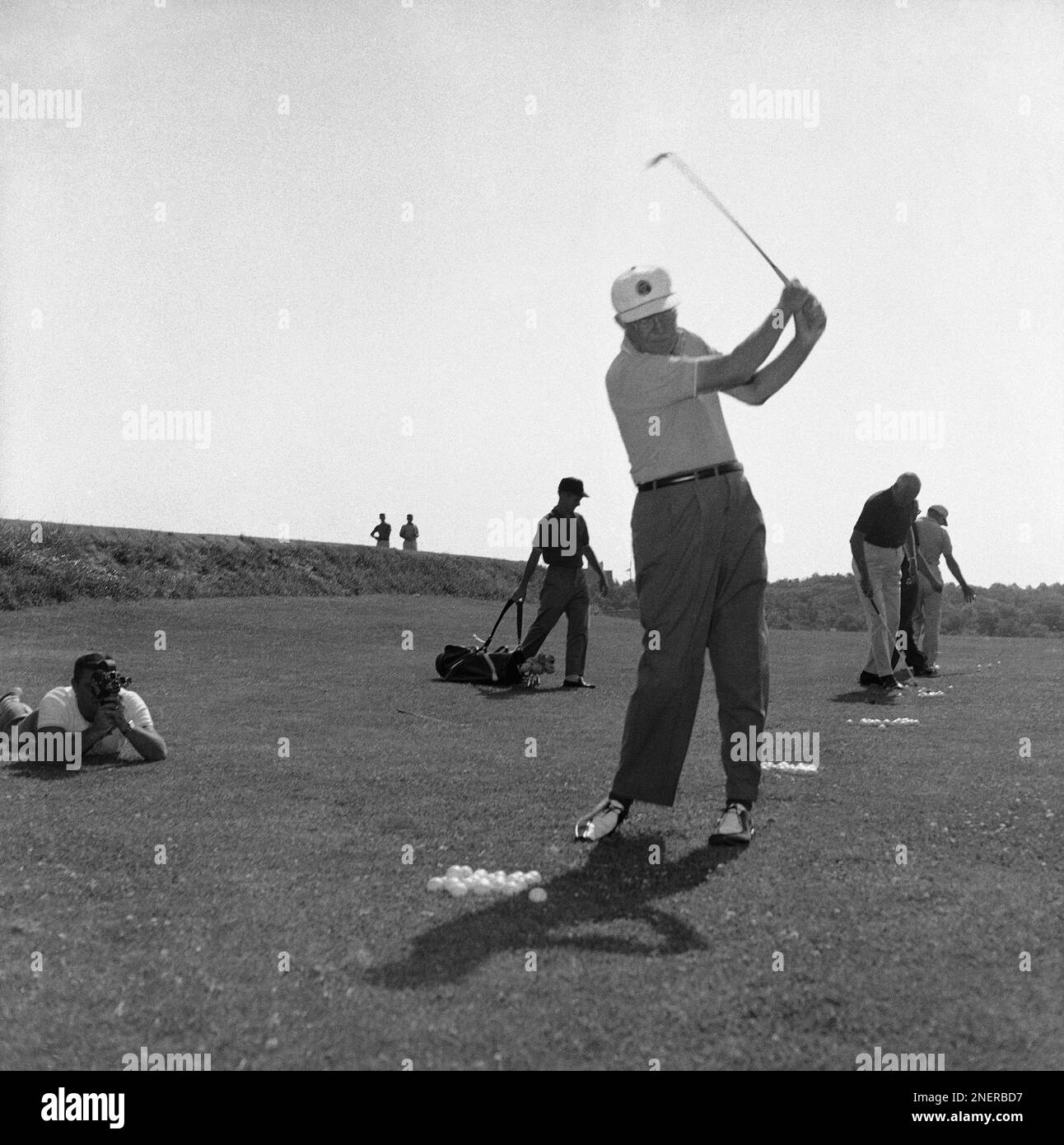 President Dwight Eisenhower practicing shots in front of clubhouse in ...