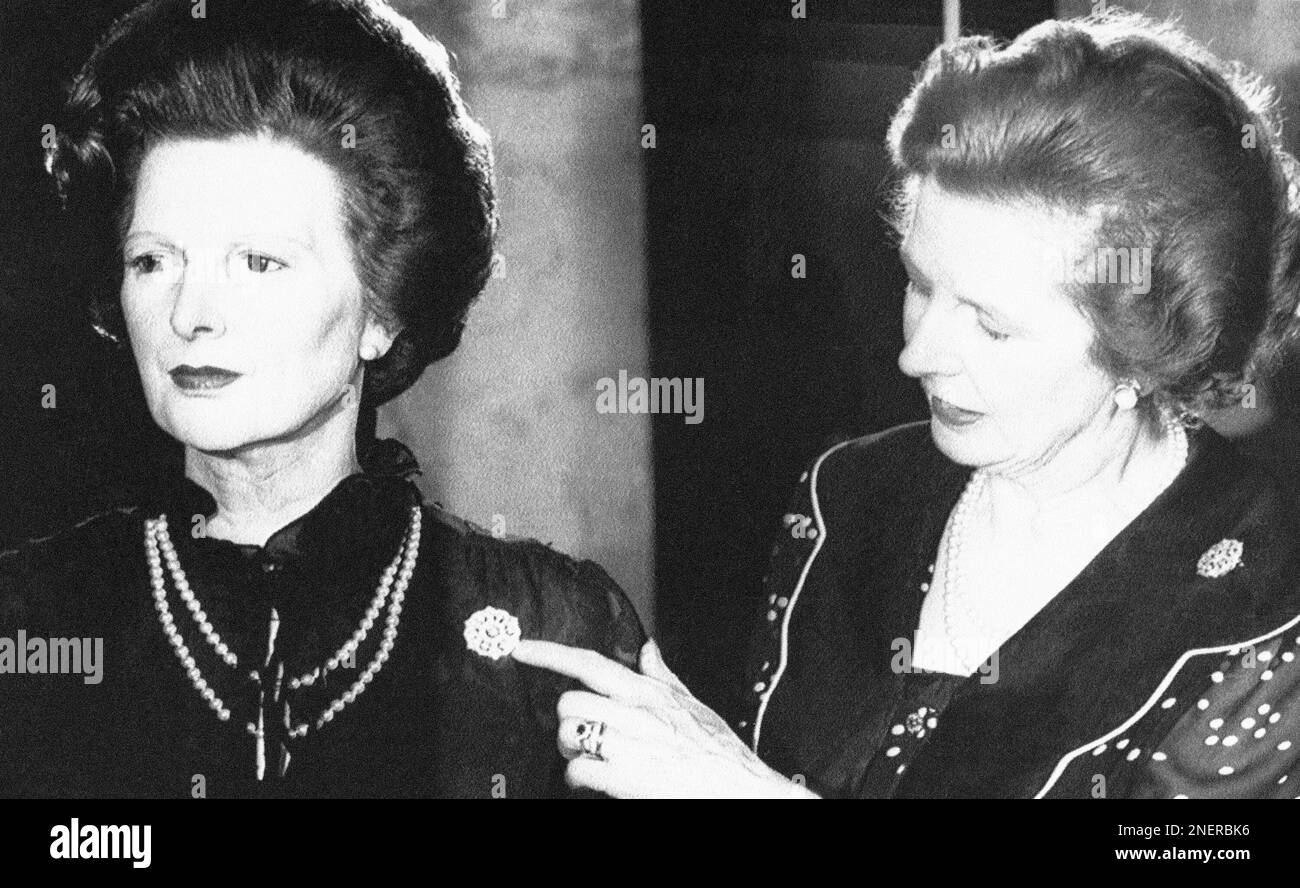 Britain?s Prime Minister Margaret Thatcher examines a brooch worn by ...