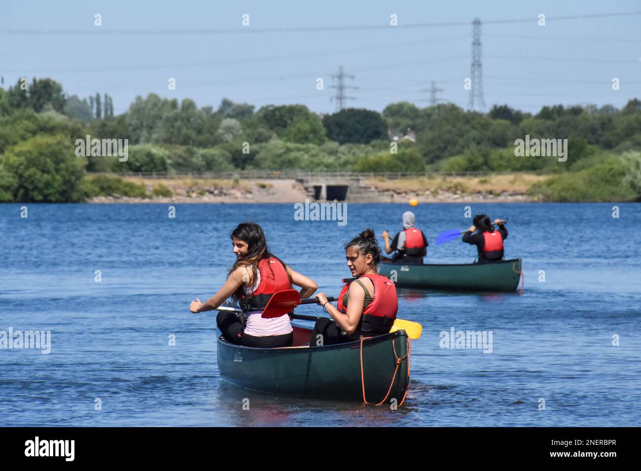 A group of young adults kayaking on a lake in summer. Staffordshire ...