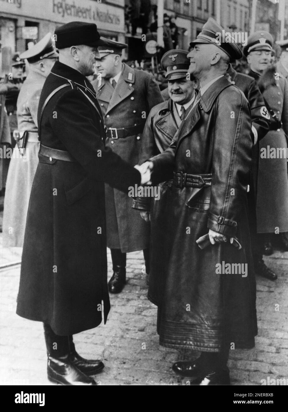 Dr. Ernst Neumann, leader of the Memel Germans, left, is shown greeting ...
