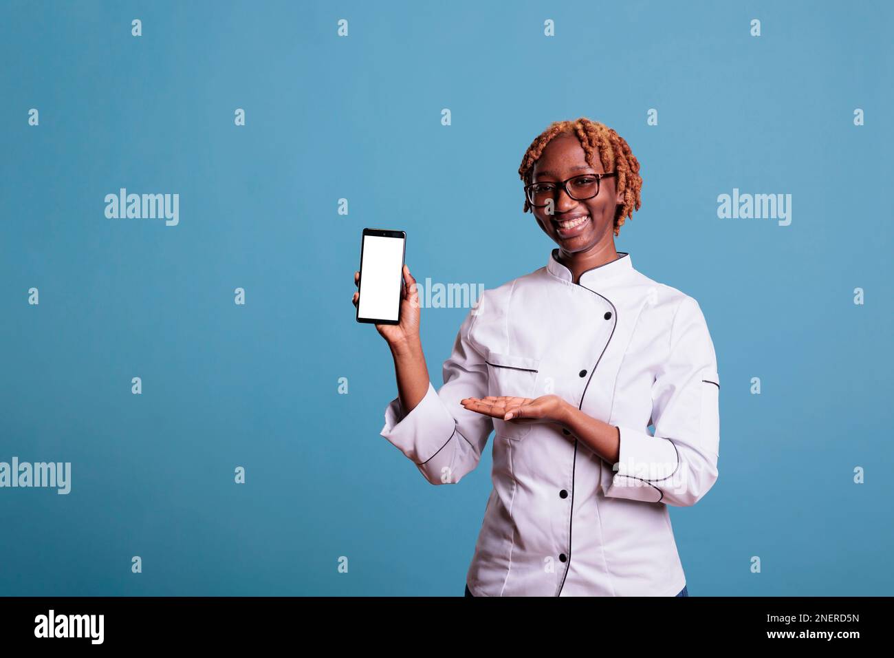 Female kitchen staff wearing work uniform holds cell phone with empty ...