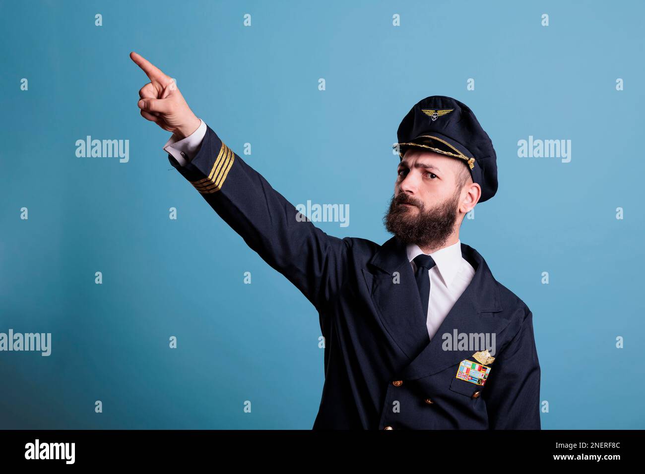 Serious captain pointing at sky with index finger, wearing professional ...