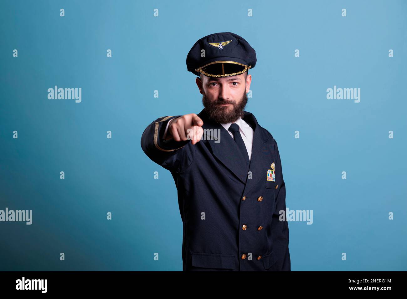 Serious airplane pilot pointing at camera, plane captain wearing ...