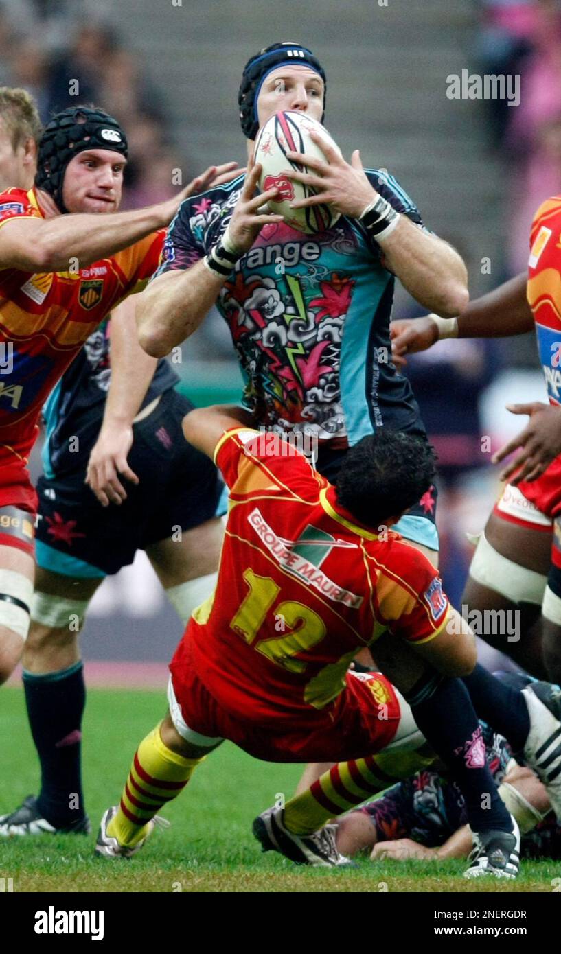 Stade Francais' James Haskell, top, is tackled by Perpignan's Maxime ...