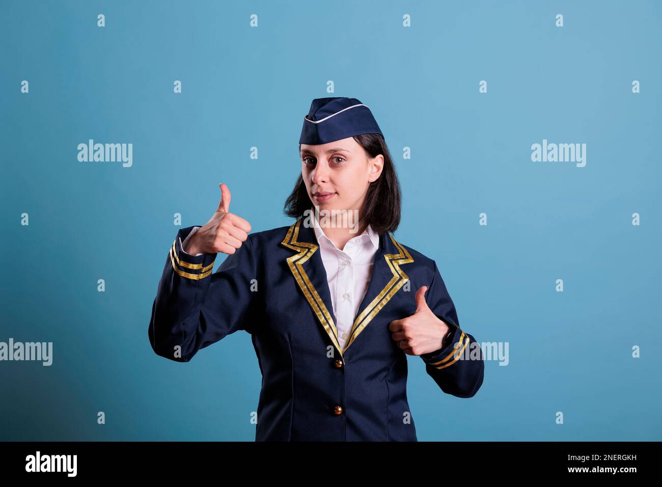 Smiling stewardess showing two thumbs up gesture, aviation academy ...