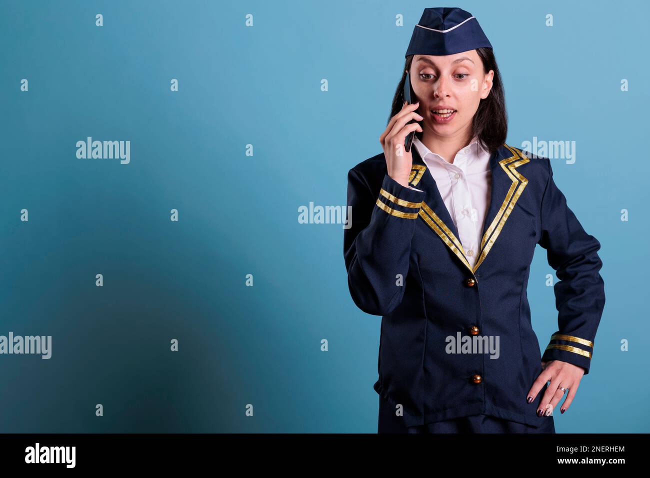Smiling cheerful stewardess talking on smartphone, having remote ...