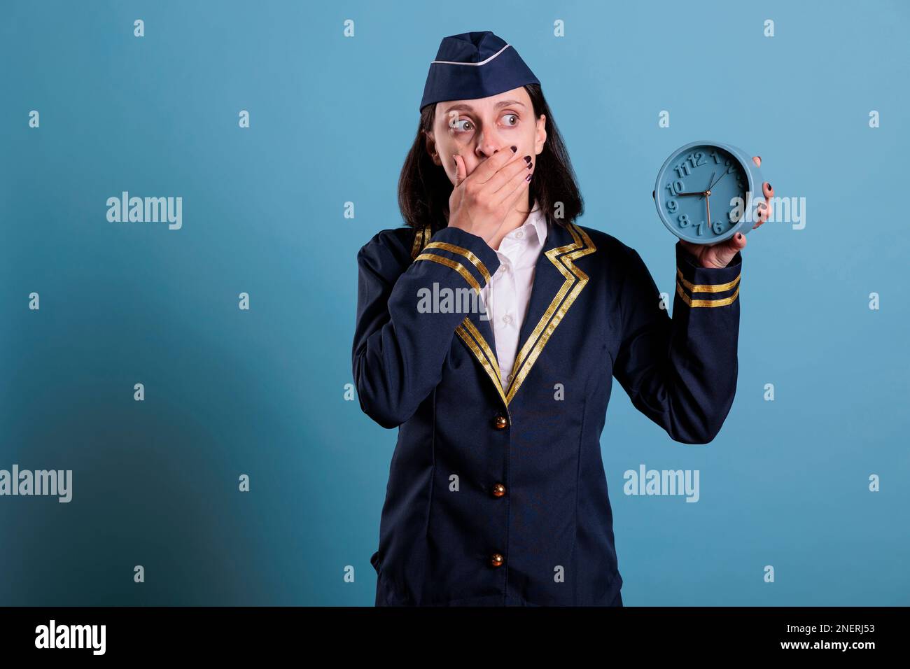 Anxious stewardess holding retro alarm clock, running late at airport ...