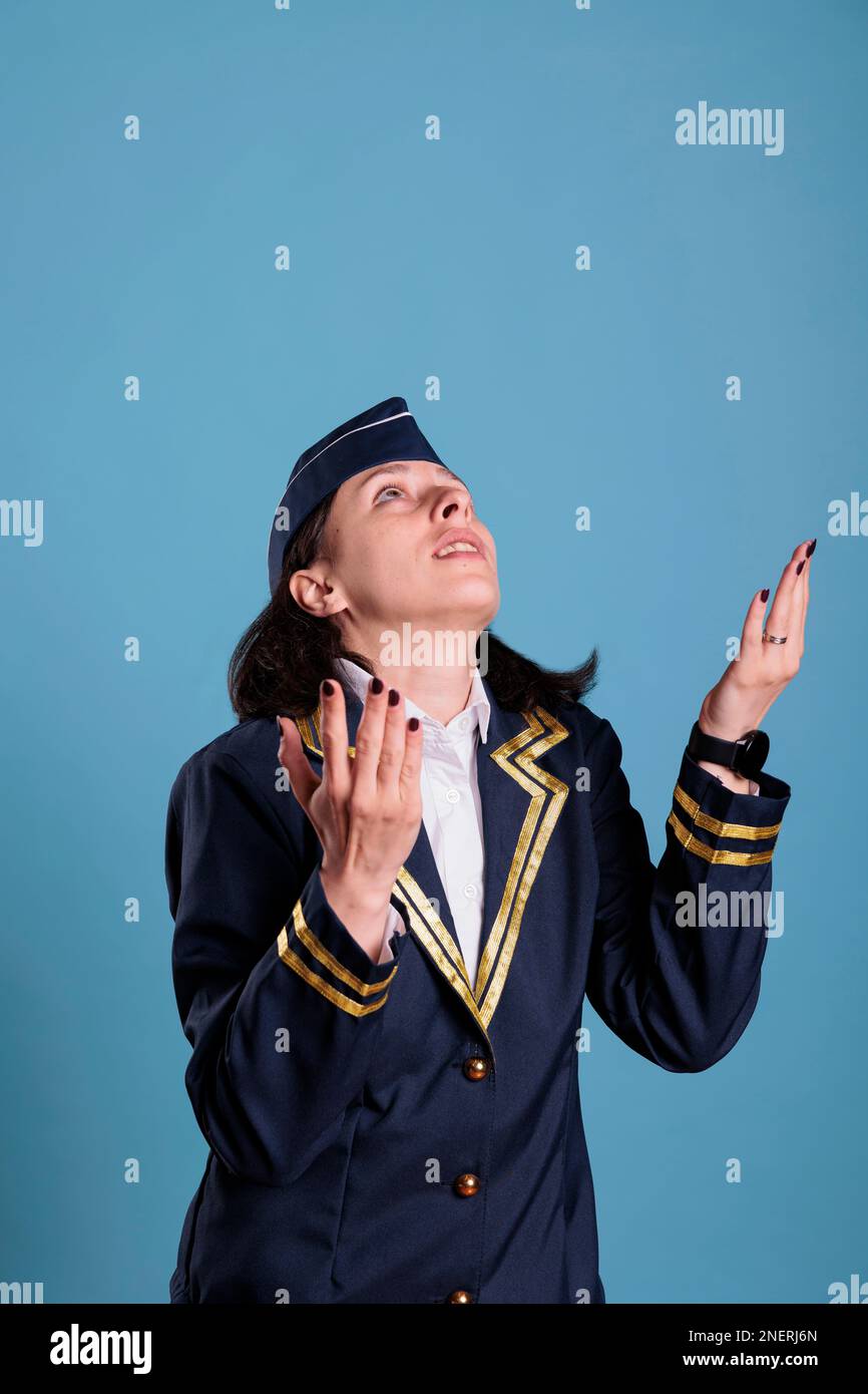 Prayer stewardess in aviation uniform begging, praying to gods, looking ...