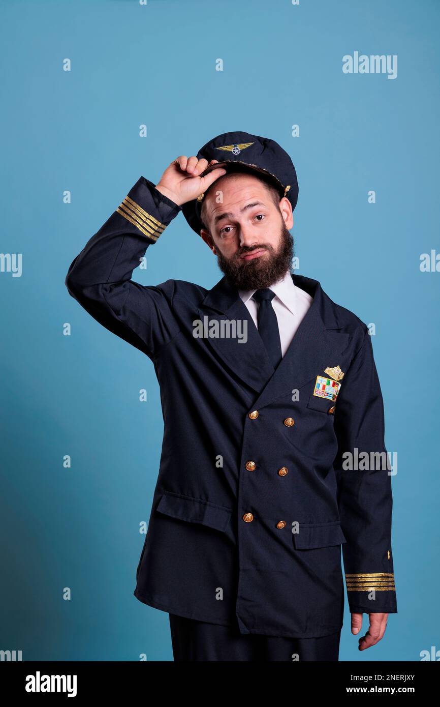 Airplane capitan taking hat off, looking at camera with confused facial ...