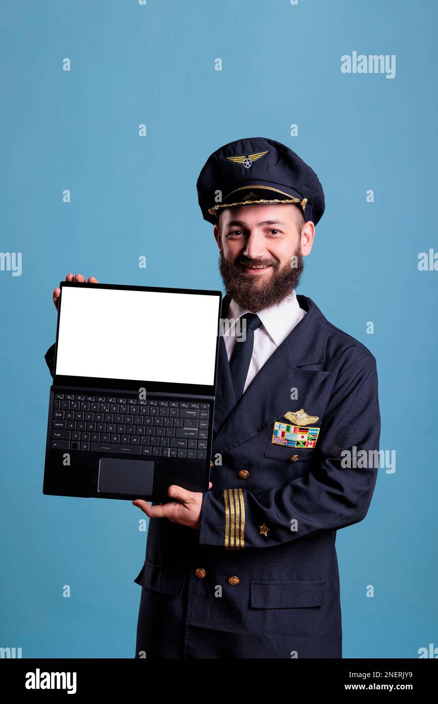Smiling airliner captain showing laptop with blank white screen ...