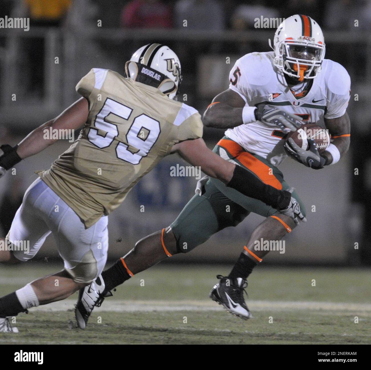 Miami running back Javarris James, right, runs past Central Florida ...