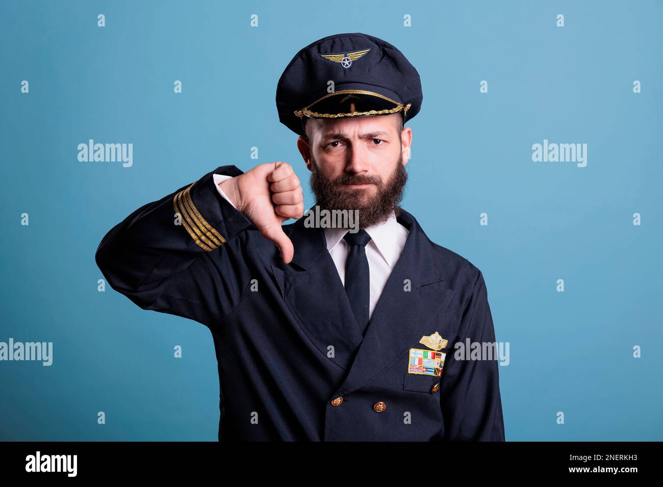 Serious airplane aviator with thumbs down gesture wearing professional ...