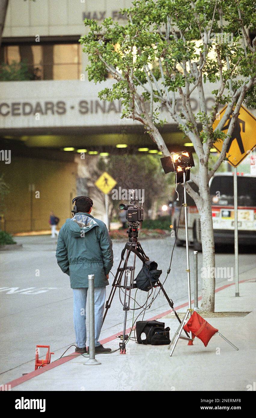 An unidentified cameraman waits outside Cedars-Sinai Medical Center in ...