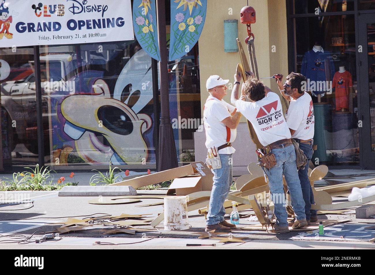 Workmen construct a weathervane for the roof of the new Club Disney ...