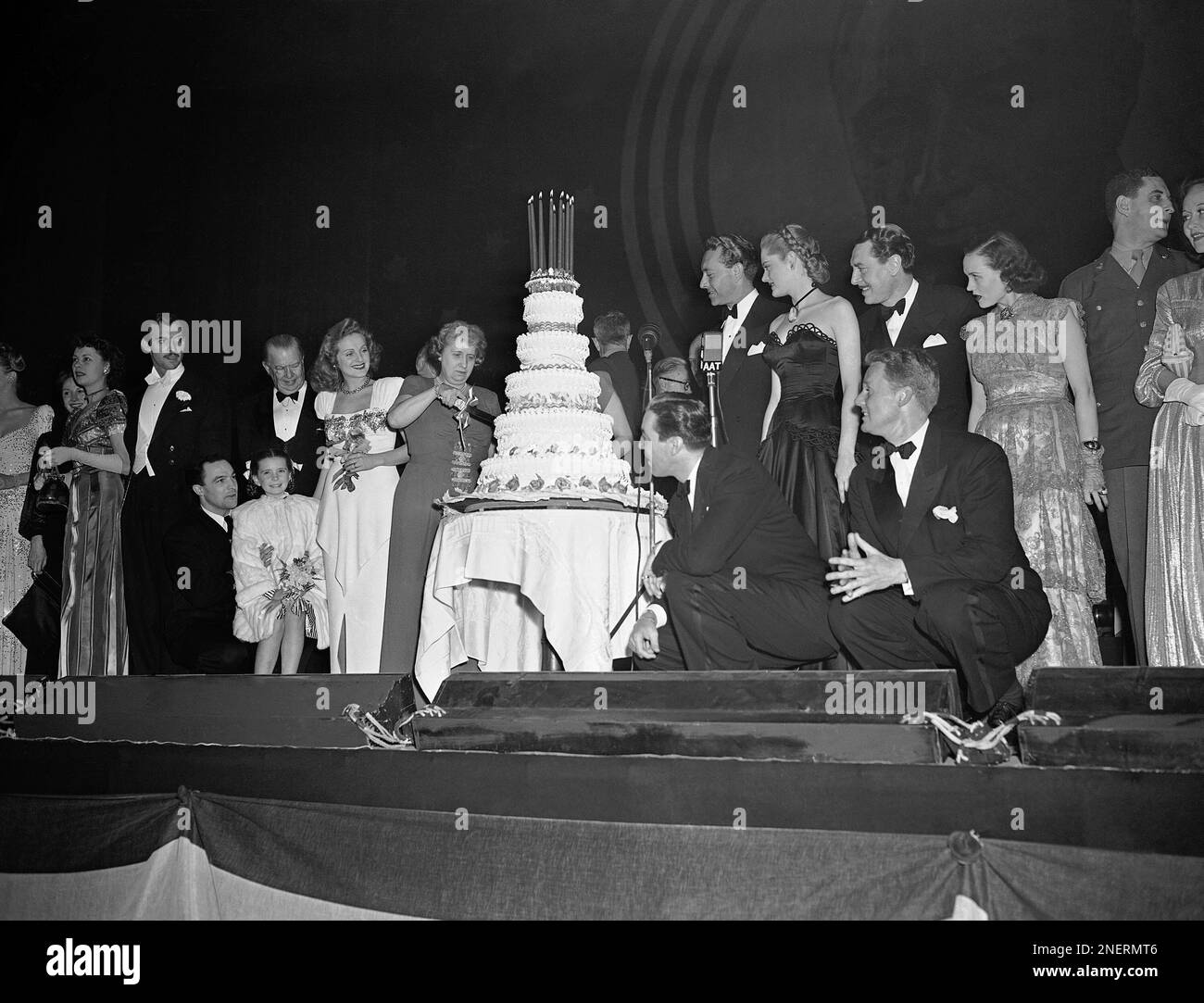 Knife poised, Mrs. Harry Truman, wife of the President, begins cutting ...