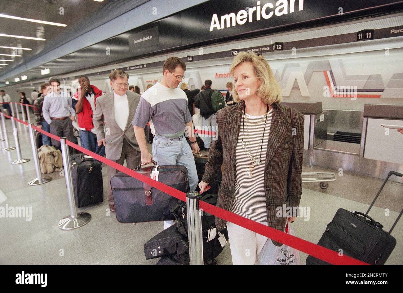 Sandy Edwards, right, and her family await their turn at the check-in ...