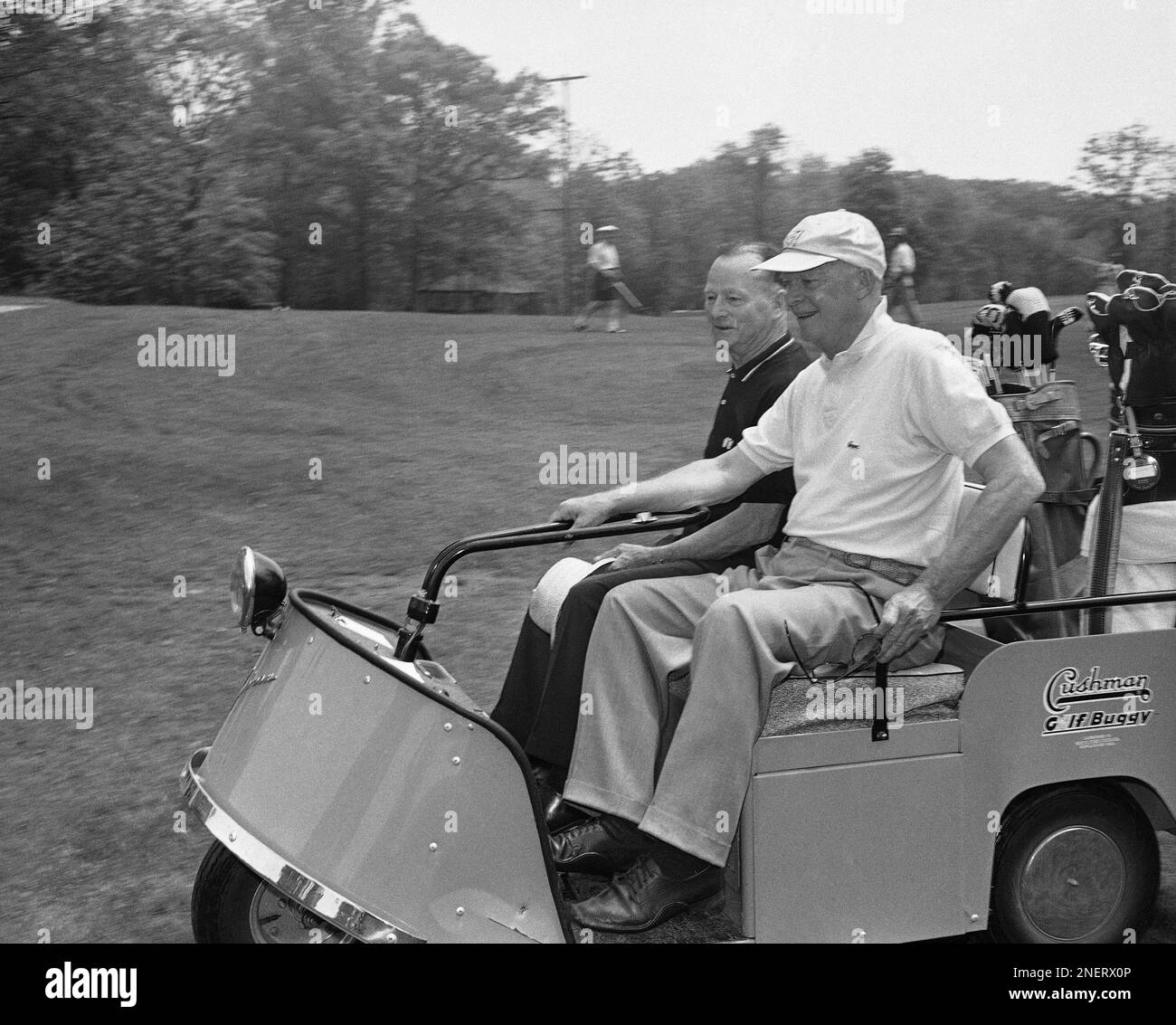 President Dwight Eisenhower drives his golf cart towards his waiting ...