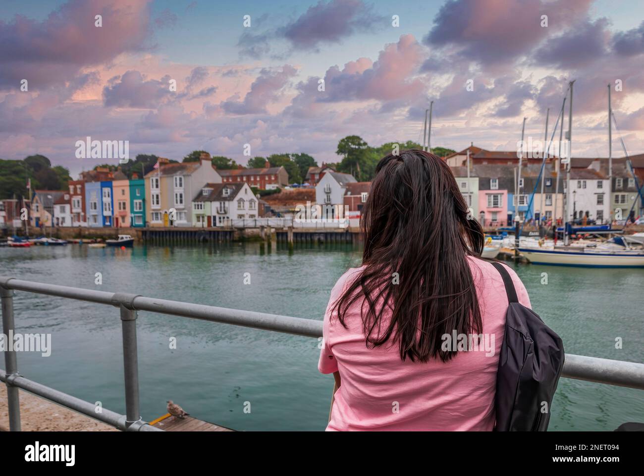 woman in focus enjoying the view of the bay with ships and boats of the ...