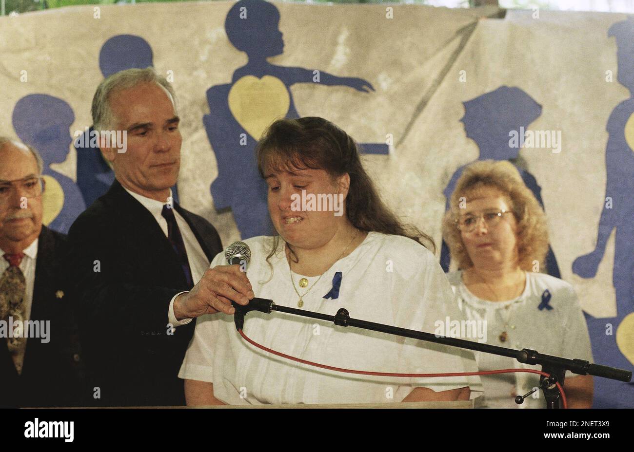 District attorney Gil Garcetti, left, adjusts the microphone for Liz ...