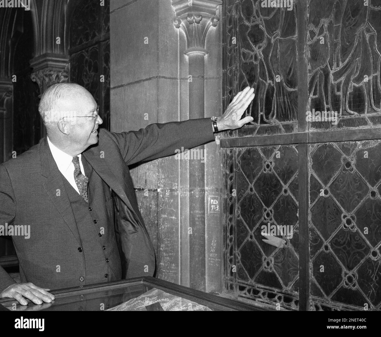 President Dwight Eisenhower runs his hand over surface of one of the ...