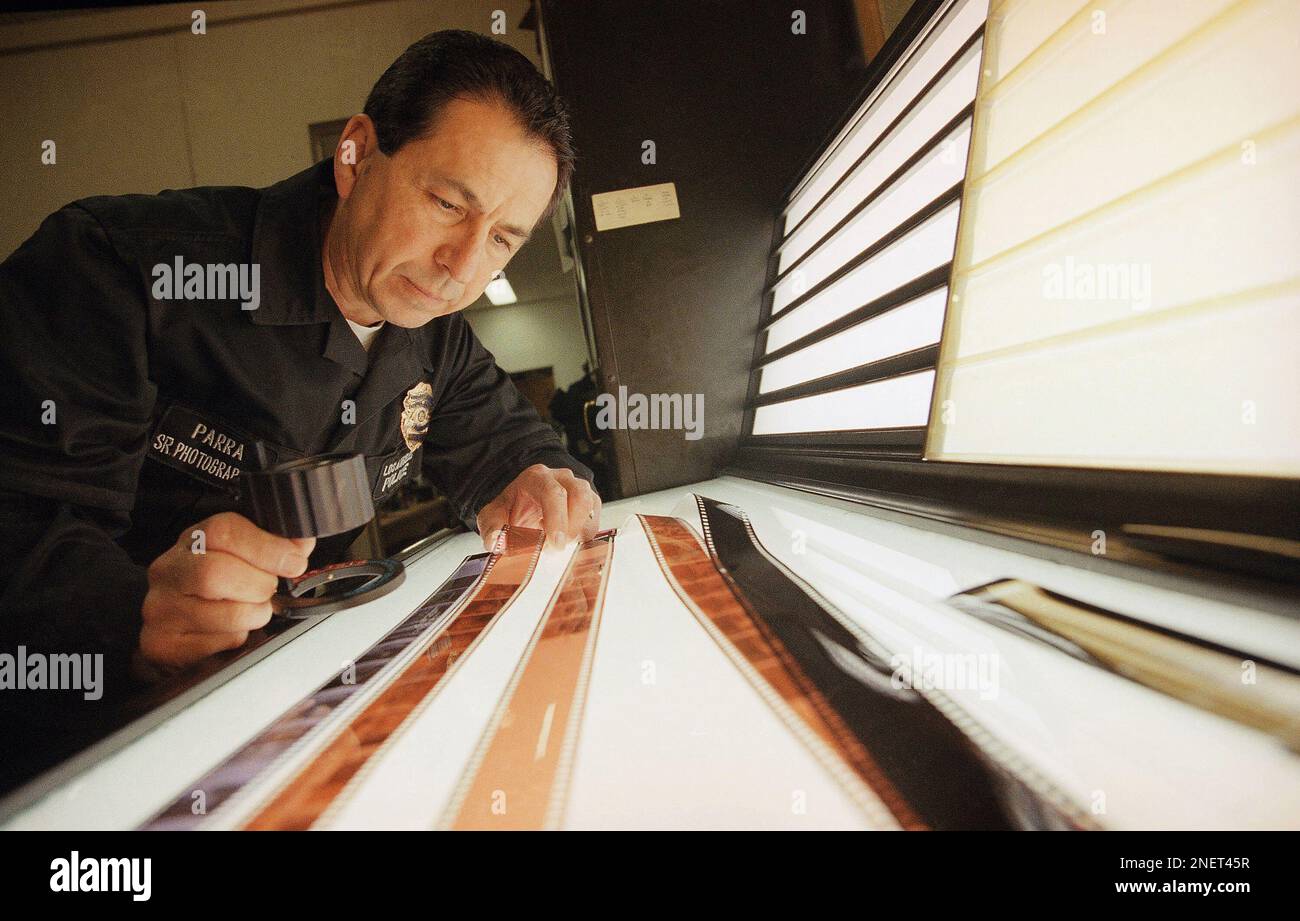 Senior Police photographer Arthur Parra looks at negatives on a light ...