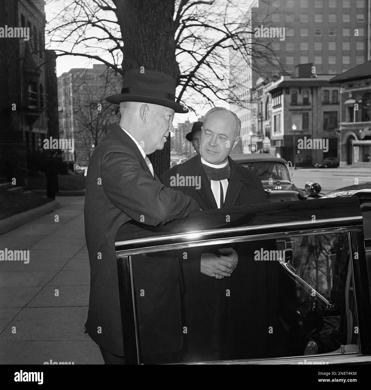 President Eisenhower leans on the open door of his car as he chats with ...