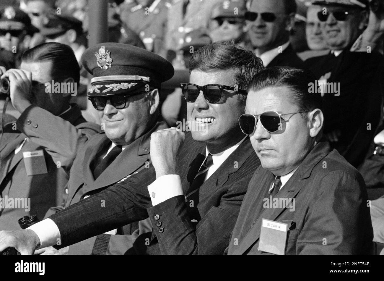 President Kennedy uses binoculars and grimaces yesterday as he views a ...