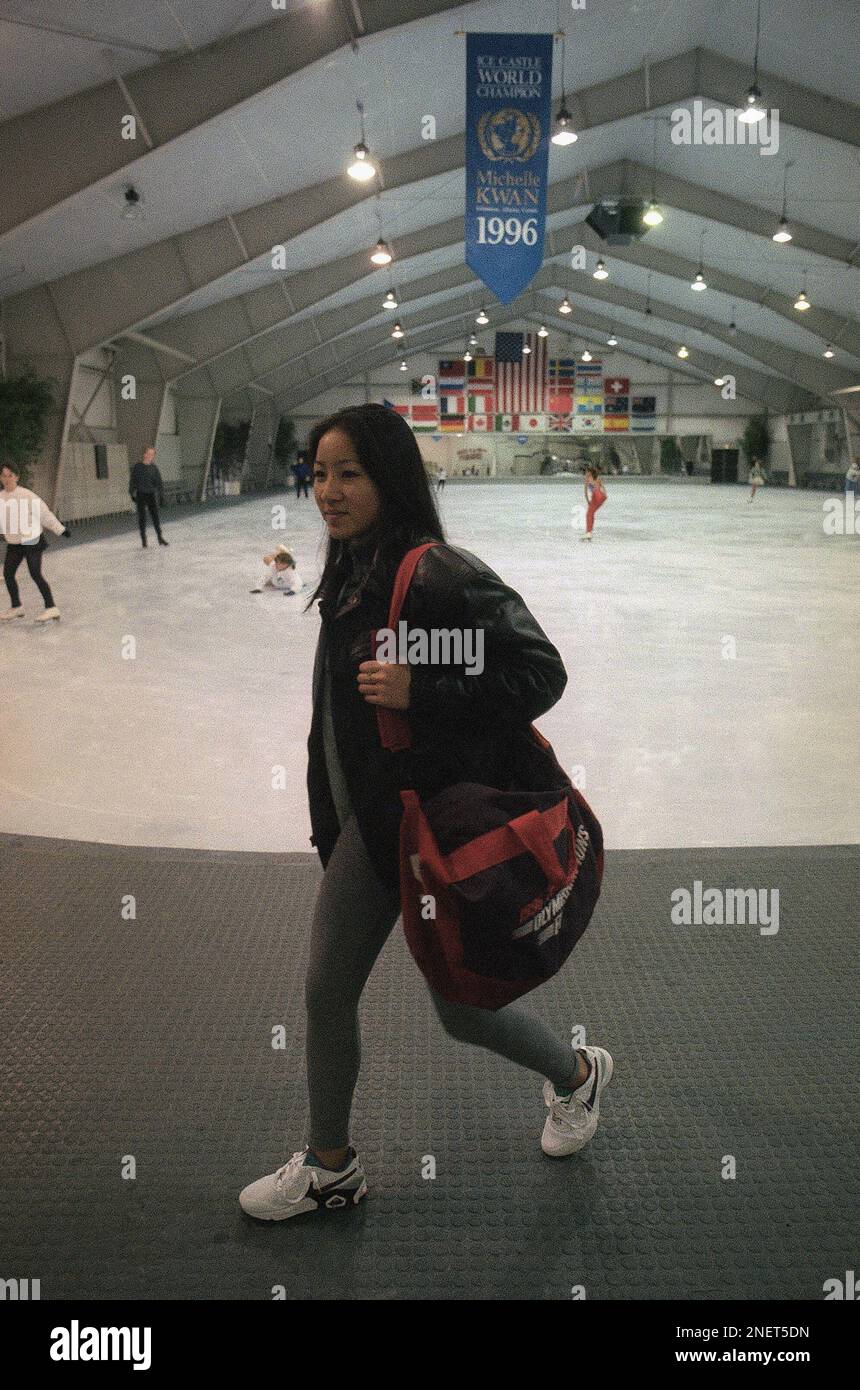 Following practice, figure skater Michelle Kwan heads off the ice rink ...