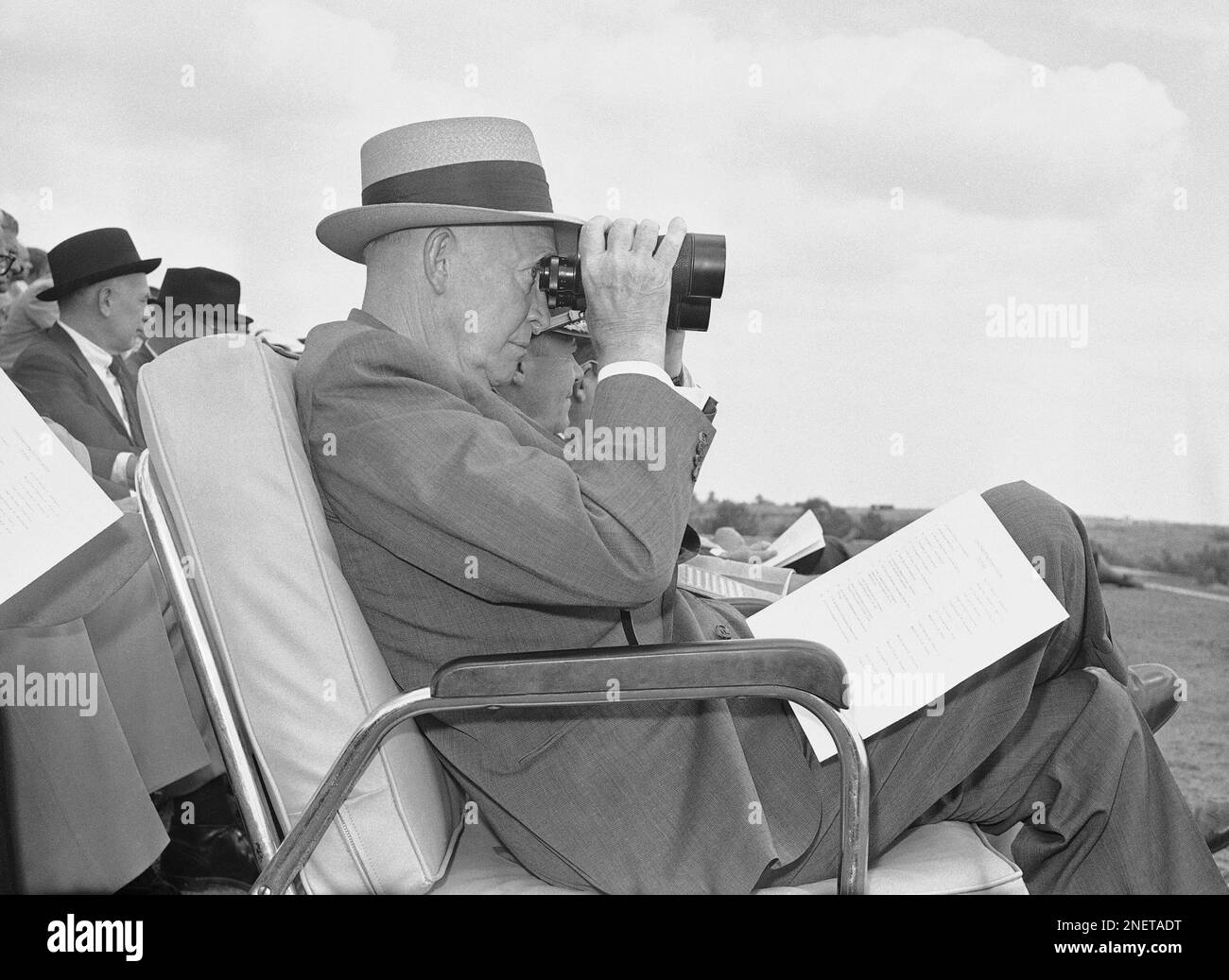 President Eisenhower looks through field glasses to get a closer look ...