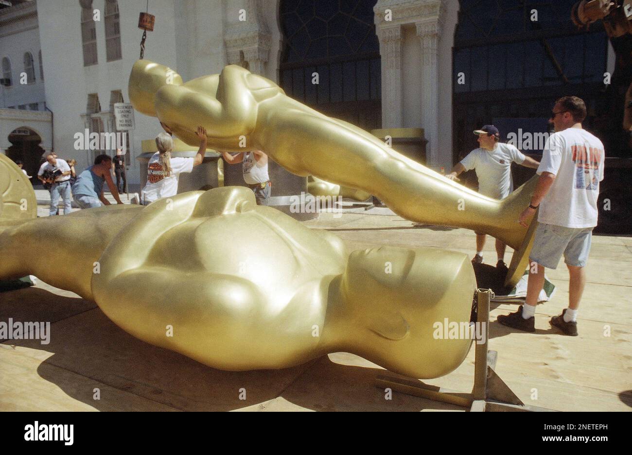 Workmen lay down 24-foot prop Oscar statues in front of the Shrine ...